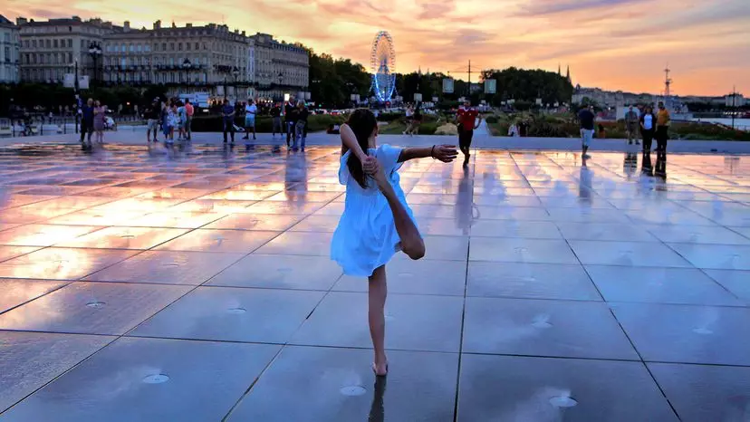 Tânăra dansează la oglinda de apă din Bordeaux