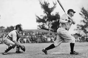 Babe Ruth sveiflar kylfu þegar grípari krækir á bak við hann á leik um 1925.