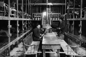 عاملان يسترخيان في أماكن نوم المهاجرين في مشروع بناء قناة بارج بولاية نيويورك عام 1909.