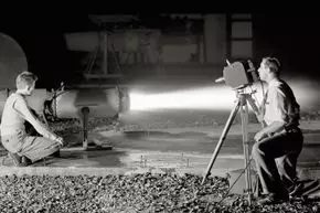 Een cameraman met een hogesnelheidscamera filmt de stuwkrachtvergrotingsvlam van een straalmotor I-40-motor in het Lewis Flight Propulsion Laboratory in Cleveland. (Het lab werd later bekend als het John Glenn Research Center.)