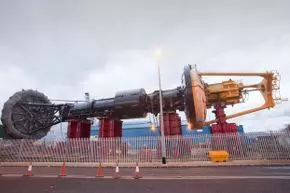 PB150 PowerBuoy ondoenergia aparato atendas sur la dokflanko en Invergordon, Cromarty Firth Skotlando.