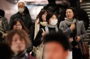 Ang mga commuter sa Tokyo nagsul-ob og mga surgical mask aron matabangan ang pagpanalipod sa ilang kaugalingon gikan sa usa ka pagbuto sa trangkaso.