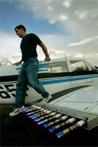 Un piloto sae do seu avión pasando por bengalas utilizadas na sementeira de nubes despois de voar unha misión en 2007 para o programa de modificación do tempo de Kansas occidental.