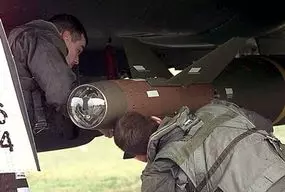 Як халабони F-15E Strike Eagle ва афсари системаи силоҳ як бомбаи лазерии GBU-28-ро тафтиш мекунанд.