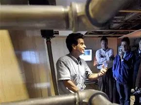 Dean Kamen, kiri, duduk di atas mesin Stirling hemat energi yang dia gunakan di Bangladesh untuk menghasilkan listrik dengan gas metana yang dihasilkan oleh kotoran sapi.