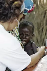 Une infirmière examine un enfant malnutri au Niger. La désertification contribue aux pénuries alimentaires du pays.