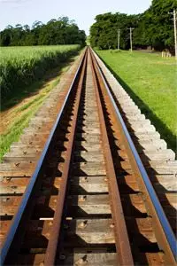 澳大利亚昆士兰附近的这些火车轨道的枕木是木制的，延伸到远处的铁轨看起来是用钢制成的。