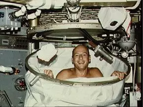 رائد الفضاء تشارلز كونراد جونيور ، قائد Skylab 2 ، يبتسم للكاميرا بعد الاستحمام بالماء الساخن في مرفق الاستحمام.