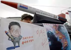 Bekas komando rahsia Korea Selatan yang memakai seragam tentera Korea Utara memegang sepanduk dengan karikatur pemimpin Korea Utara Kim Jong-Il semasa demonstrasi mengecam ujian nuklear Korea Utara.