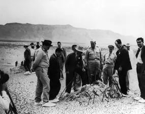 Les responsables du projet Manhattan, dont le Dr Robert J. Oppenheimer (chapeau blanc) et le général Leslie Groves, inspectent le site de détonation du test de la bombe atomique Trinity.