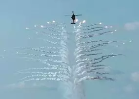 یک هلیکوپتر نیروی دریایی ایالات متحده شعله های آتش را پرتاب می کند