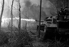 Tankên şewatê yên Tabûra Tankê ya 1emîn di dema Operasyona Doserê de êrîşî gundê No-name, li parêzgeha Quang Ngai ya Vîetnamê dikin.