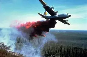 一架空中加油机将水和阻燃剂洒在野火上。
