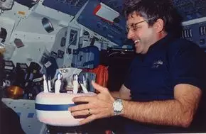 Kadangkala makanan angkasa lepas bukan makanan: Angkasawan Daniel Brandenstein memegang kek kembung sempena ulang tahunnya yang ke-47 di atas Space Shuttle Columbia.