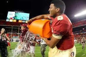 Mae Jameis Winston o Seminoles Talaith Florida yn taflu bwced Gatorade ar y prif hyfforddwr Jimbo Fisher ar ôl i'r Seminoles ennill Bowlen Oren 2013. Mae'r