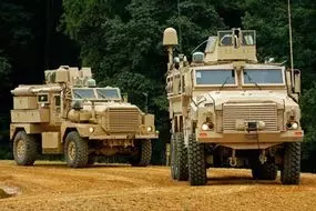 Un vehicle protegit per emboscada de categoria I (esquerra) i categoria II resistent a les mines (MRAP) condueix per un recorregut tot terreny durant una manifestació a Aberdeen, Maryland. Hi ha hagut una gran demanda de vehicles a l'Iraq.