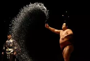Sumo glímukappinn Chiyotaiki hreinsar hringinn með salti á Grand Sumo Championship.