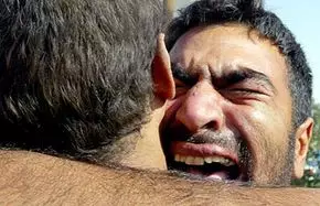 Un Irakien embrasse son frère en novembre 2005 après avoir été libéré de la prison d'Abu Ghraib, un site où certains prisonniers ont été ligotés, cagoulés et dégradés sexuellement par l'armée américaine.