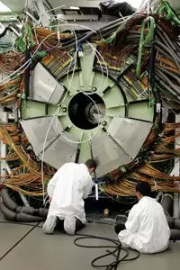 කාර්මික ශිල්පීන් ස්විට්සර්ලන්තයේ CERN රසායනාගාරයේ අංශු ත්වරණකාරකයේ භාවිතය සඳහා සොලෙනොයිඩ් චුම්බකයක් මත වැඩ කරයි. Lisi ඔහුගේ E8 ආකෘතියේ භාවිතා කළ න්‍යායාත්මක අංශු කිහිපයක පැවැත්ම මෙම ත්වරණකාරකයට ඔප්පු කළ හැකිය.