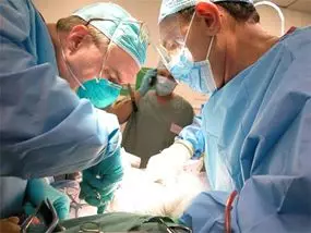 Un cirurxián de Alcor realiza procedementos iniciais para acceder ao sistema vascular dun paciente, preparándose para o proceso de vitrificación.